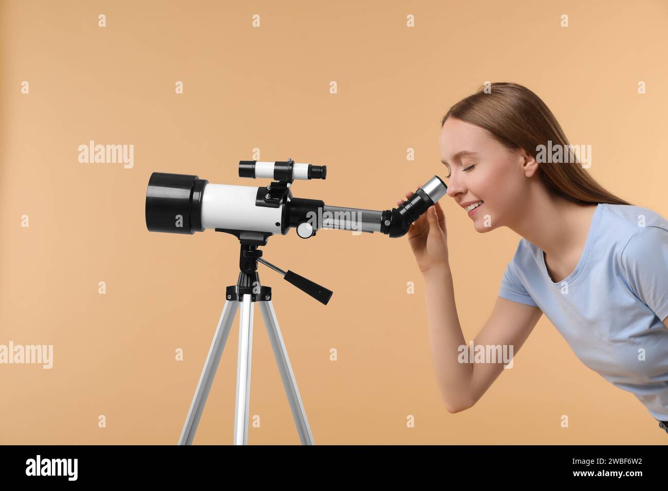Young woman looking through astronomical hi-res stock photography and ...
