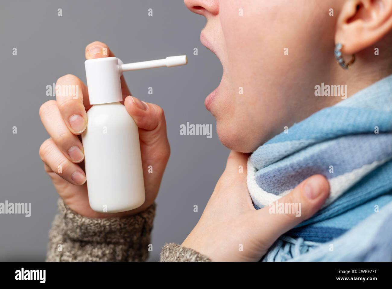 A Woman With A Sore Throat Sprays Medicine Aerosol Spray Down Her