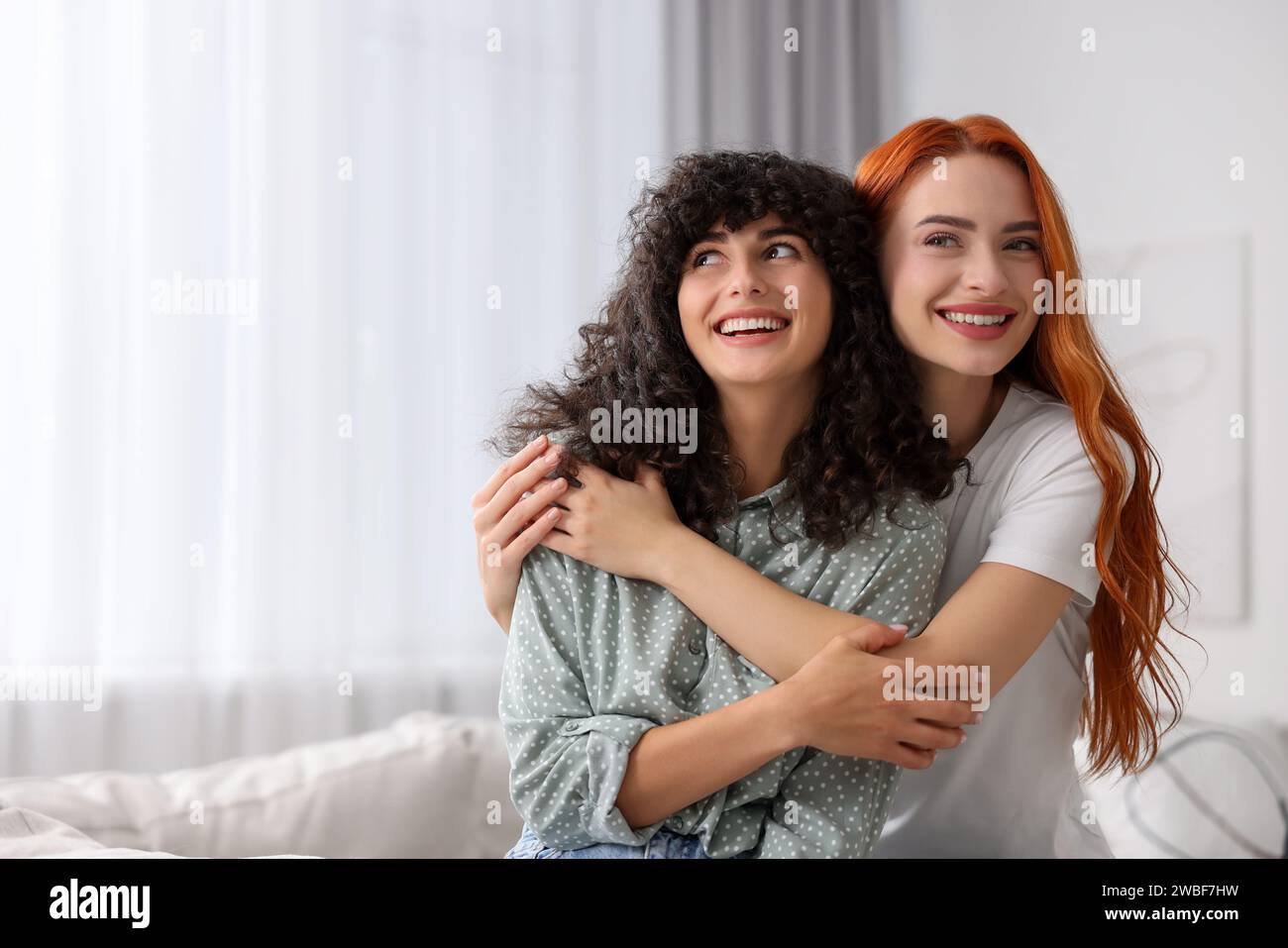 Portrait of happy young friends hugging at home, space for text Stock ...