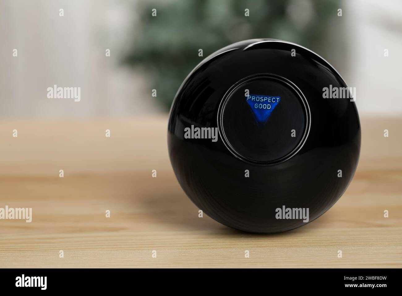 Magic eight ball with prediction Prospect Good on wooden table, closeup ...
