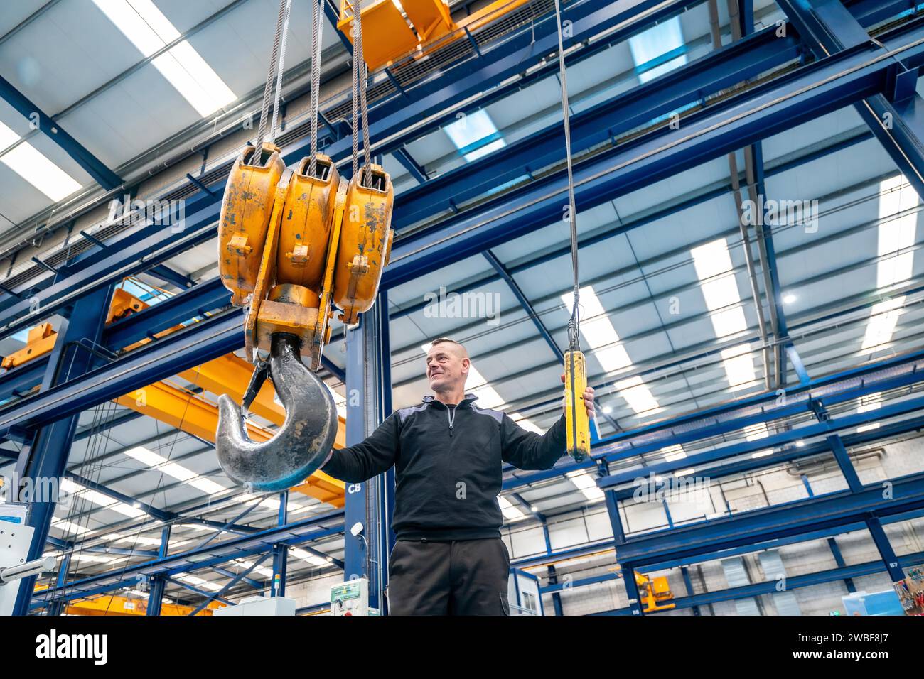 Operator controlling a industrial crane with remote control in a ...