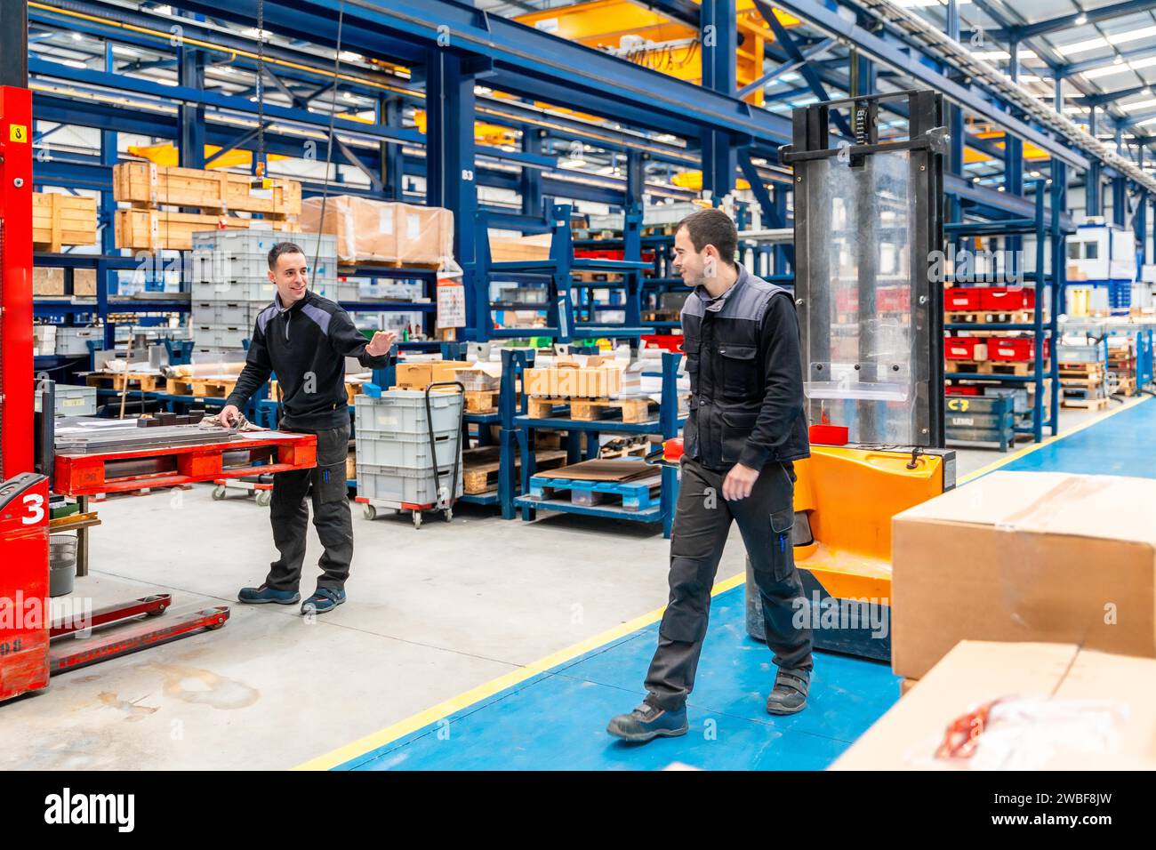 Team of warehouse and handling workers in a modern logistic factory ...