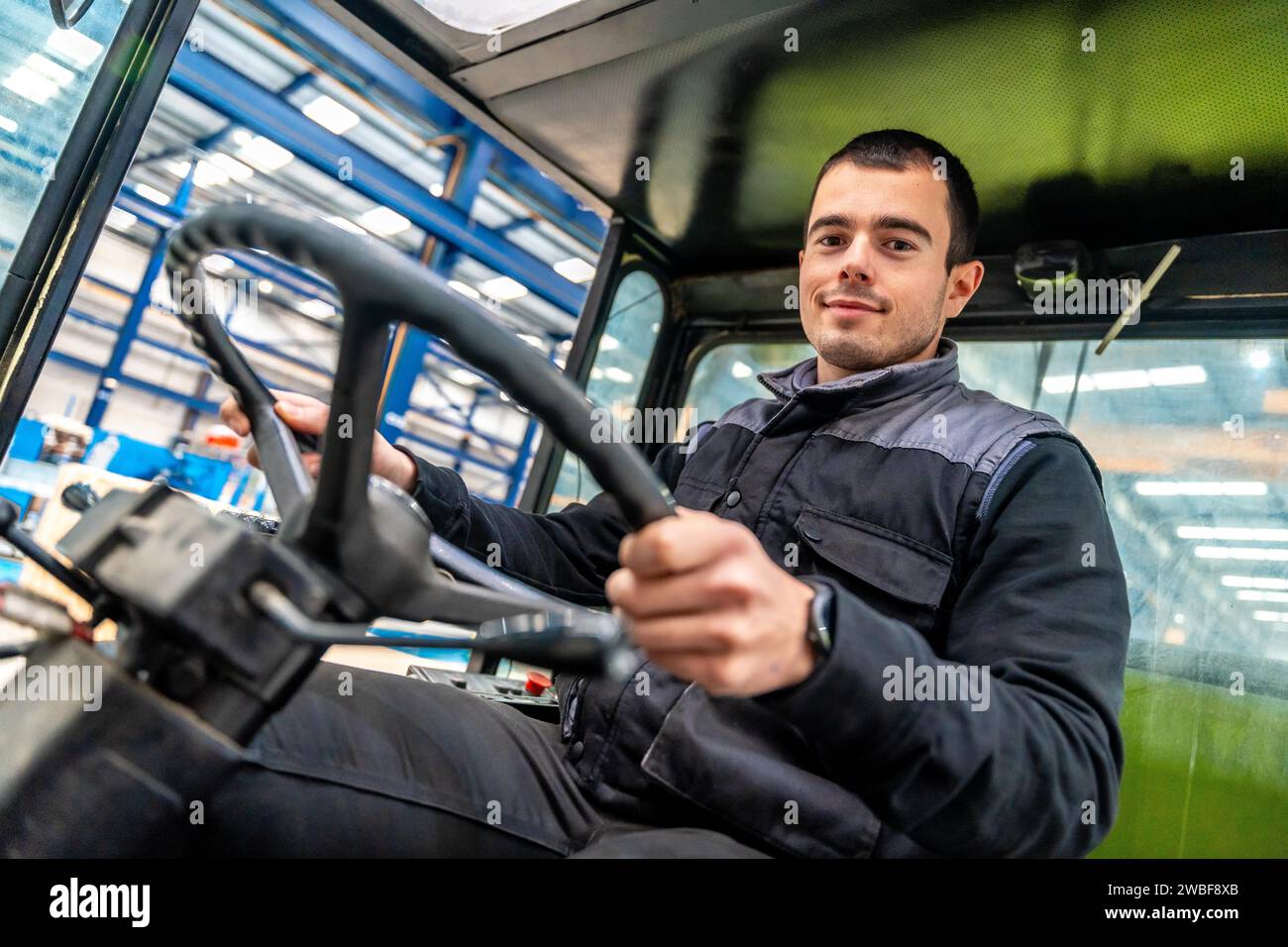 Male woker driving a forklift in a modern cnc logistic factory Stock ...