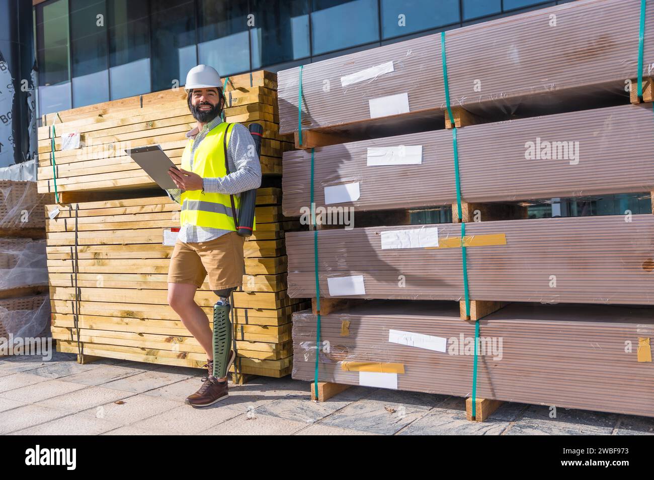 Engineer with prosthetic leg working outdoors with paperwork in a ...