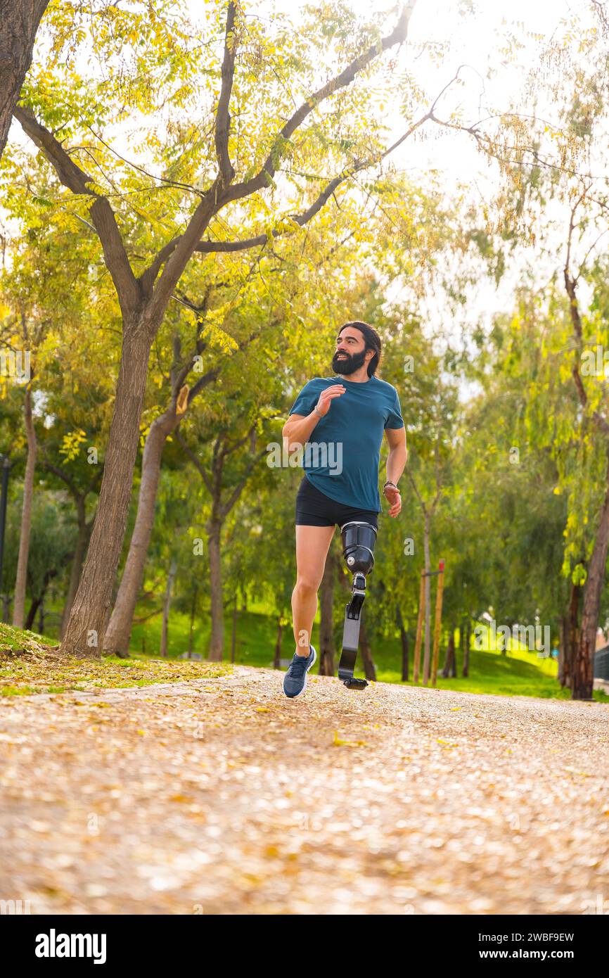 Vertical photo with low angle view of a man with prosthetic leg running ...