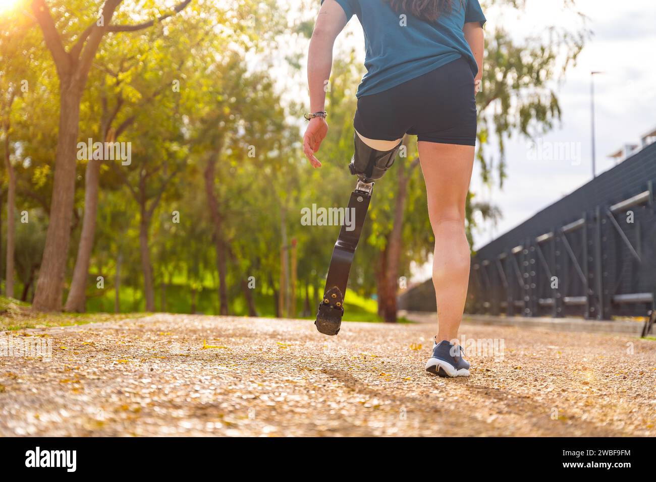 Close-up rear view of a disabled man with prosthetic leg running ...