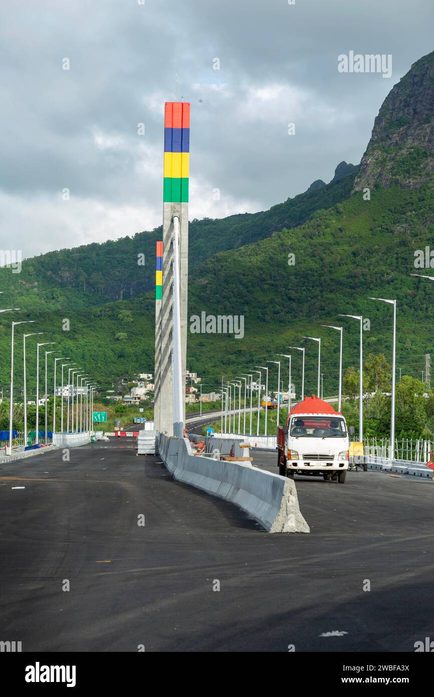 A highway with Mauritian emblem on pillar and a truck driving ...