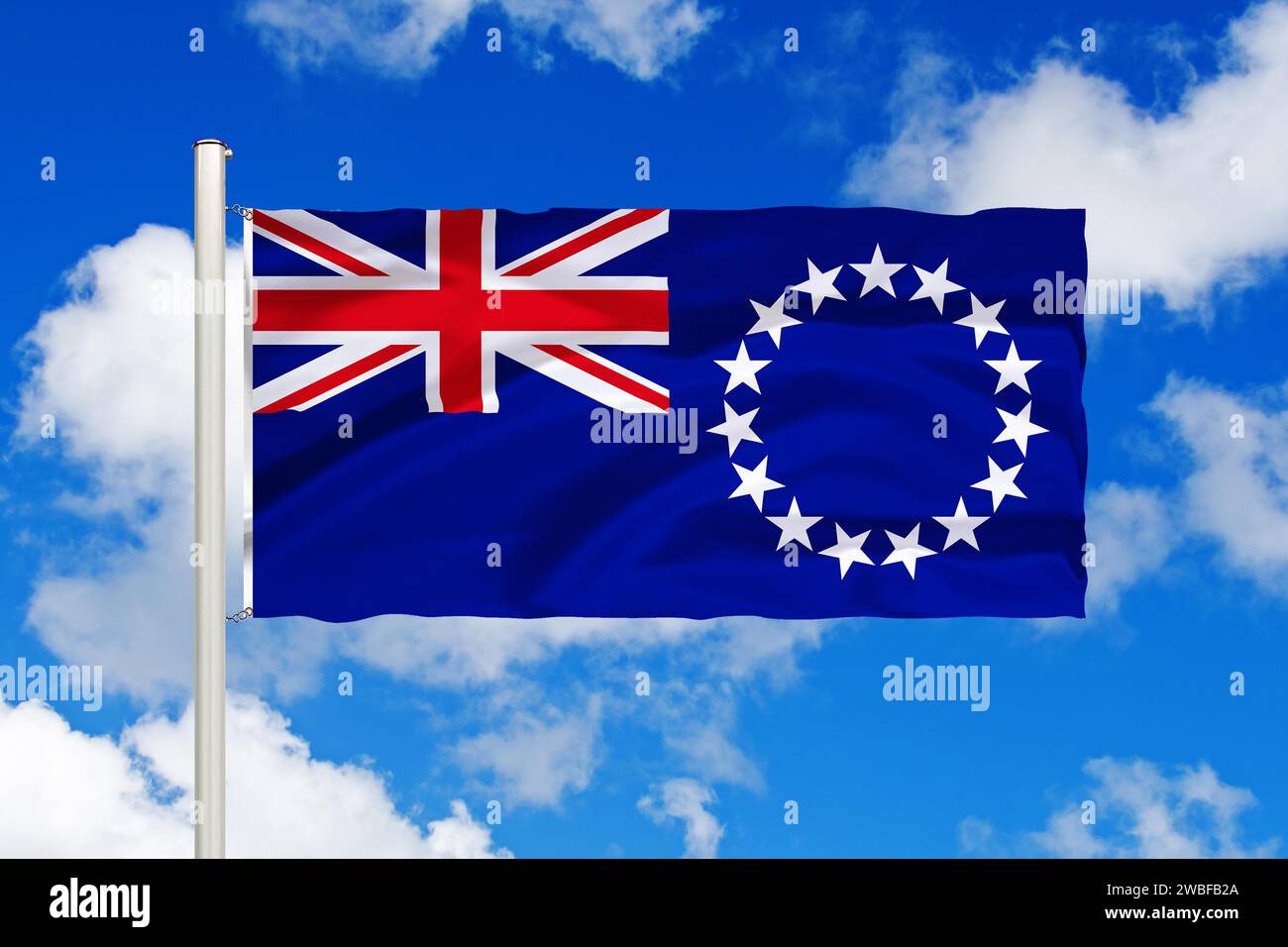 National flag of the Cook Islands in front of cumulus clouds and blue ...