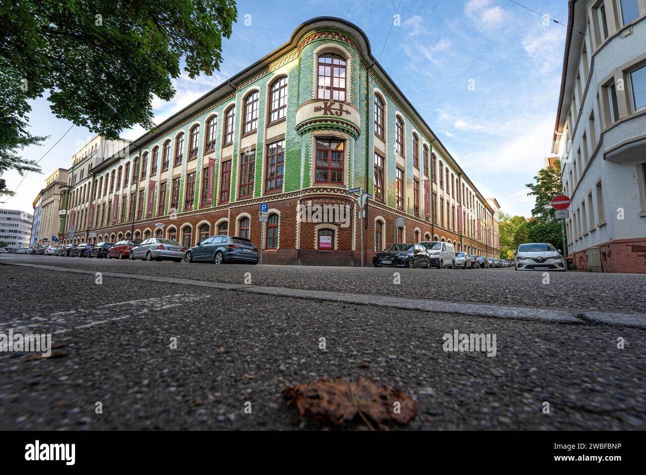 Wide-angle perspective of a historic building with green tiled facades ...