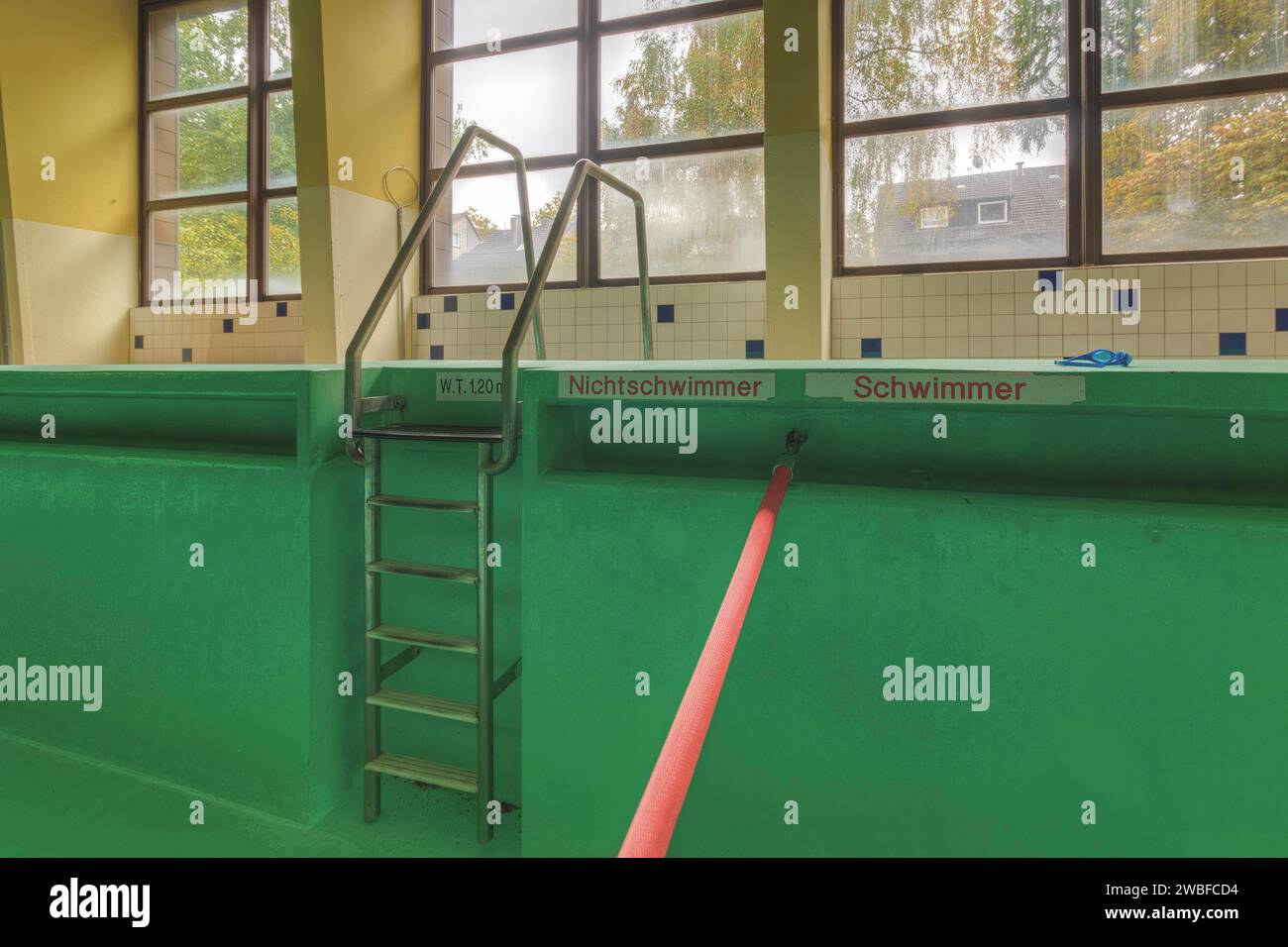 Abandoned swimming pool with signs for non-swimmers and swimmers' areas ...
