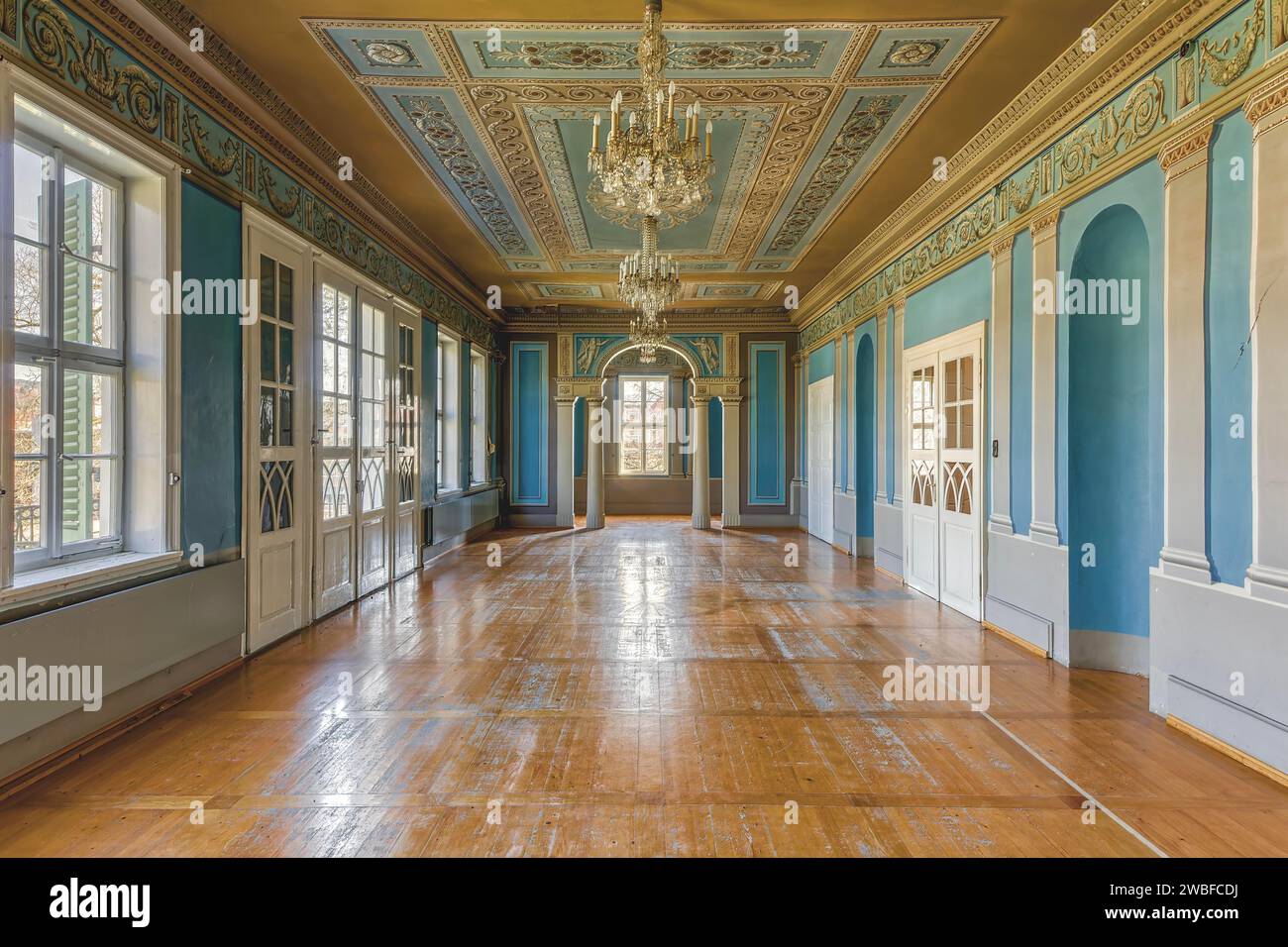 Empty historic room with wooden floor and richly decorated blue walls ...