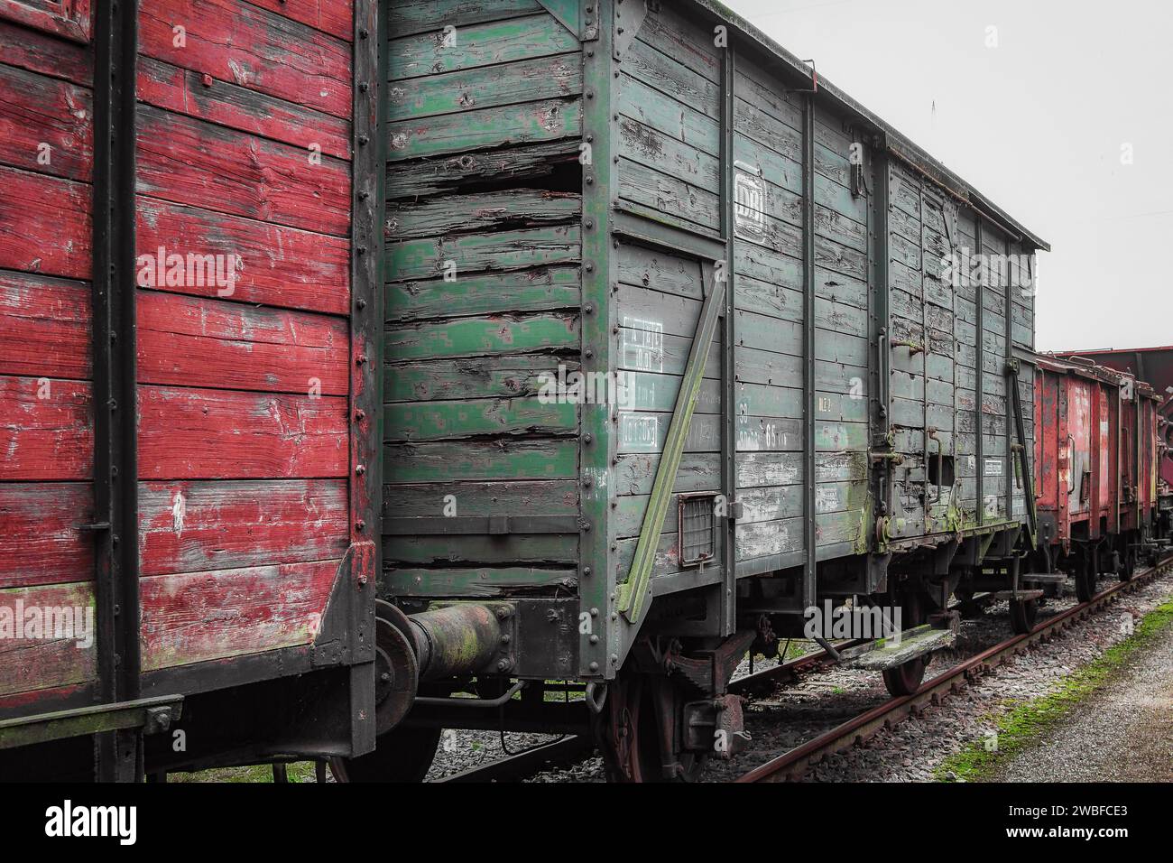 A weathered red and green goods wagon stands on tracks in the railway ...