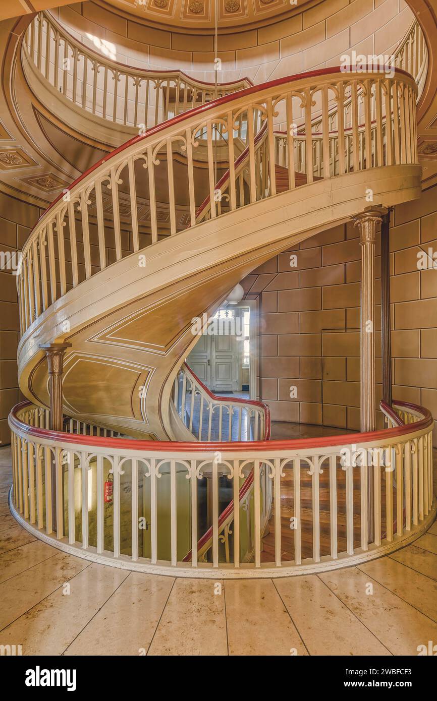 Interior view of a spiral staircase with wooden floors and white ...