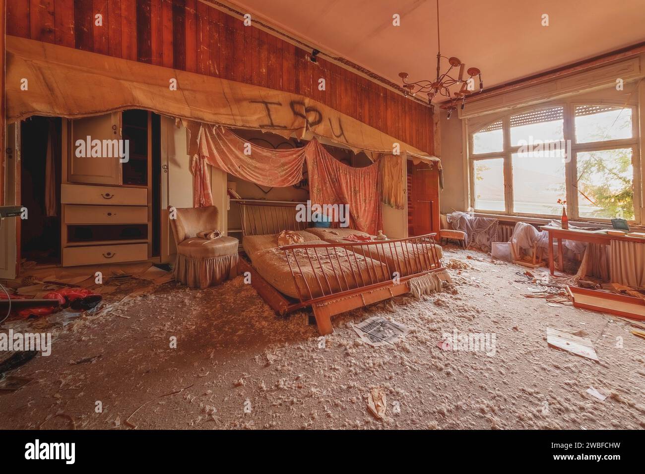 An abandoned and devastated bedroom with overturned furniture and ...