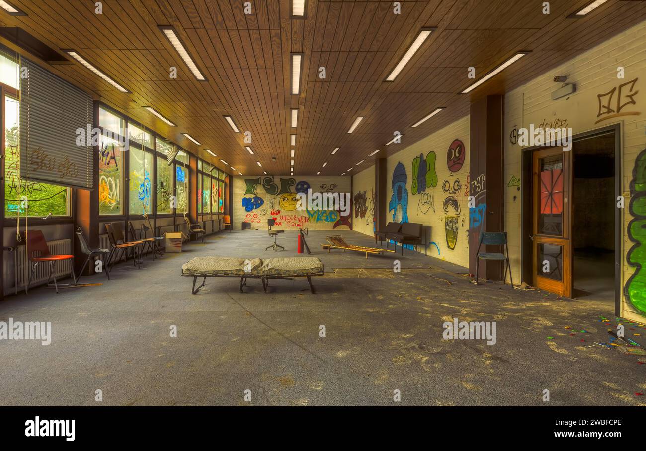 An abandoned hallway with colourful graffiti, destroyed furniture and ...