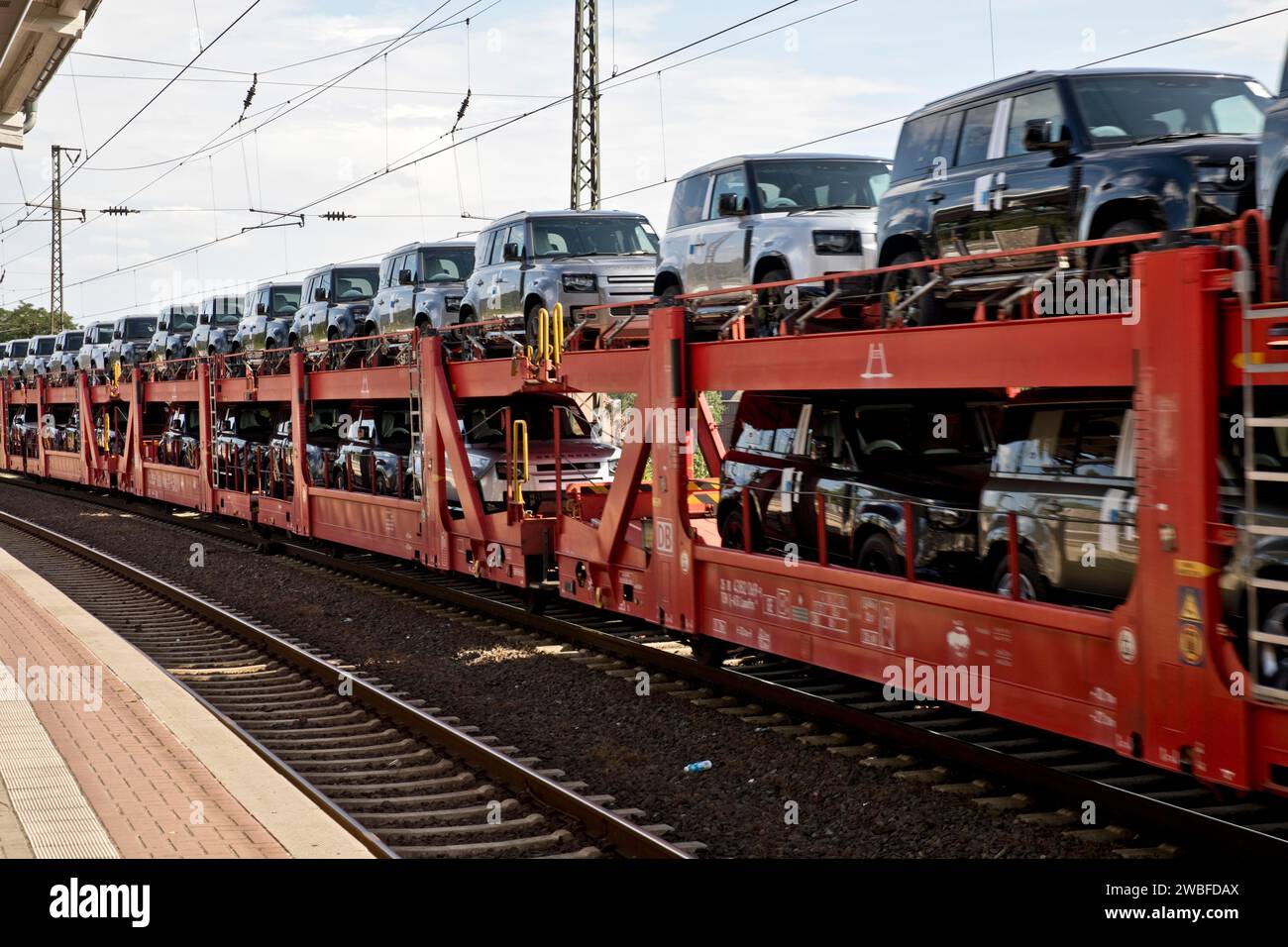 Passing goods train transporting brand-new cars, main railway station, Witten, North Rhine ...