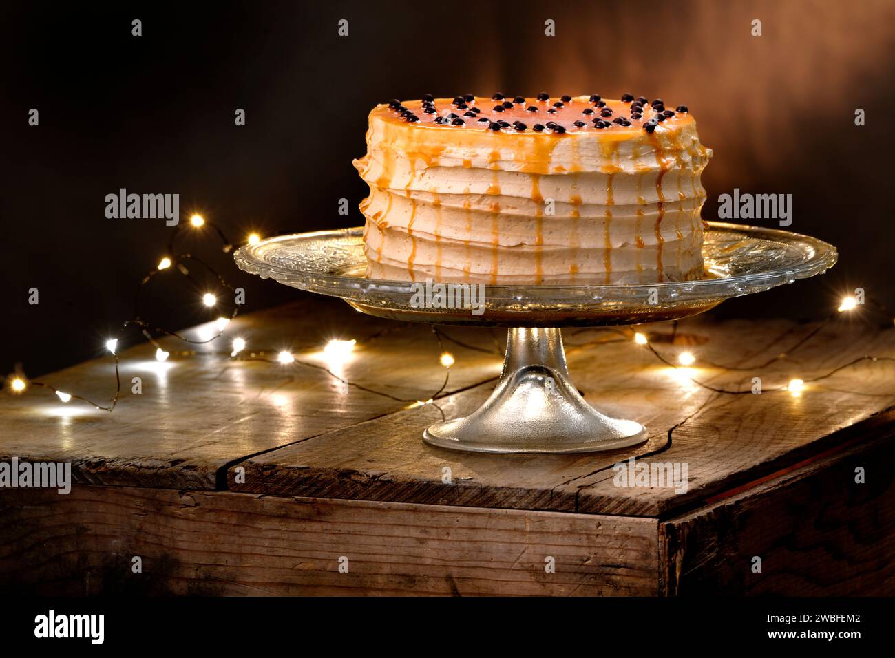 A delicious three-tiered cake with smooth chocolate-flavored icing sits ...