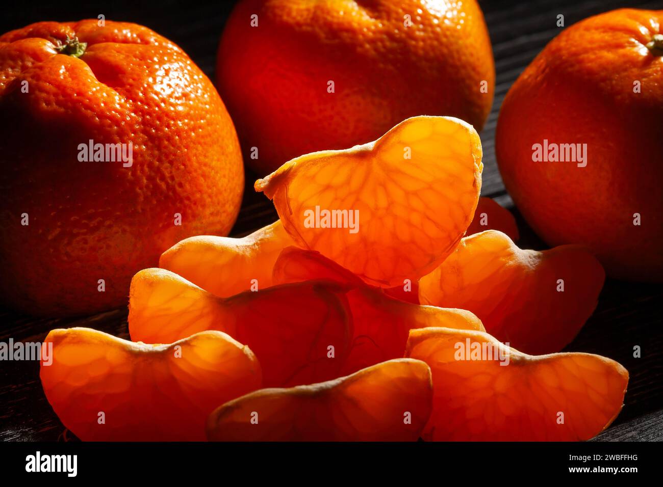 sliced tangerine on black background Stock Photo - Alamy