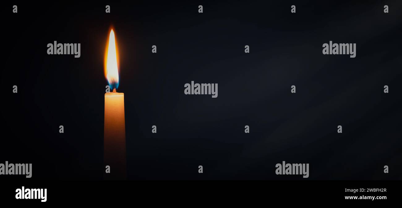 Candle burning in darkness over black background. Commemoration ...