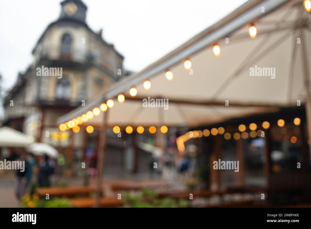 Warm festive bokeh of string lights over an outdoor bar and restaurant ...