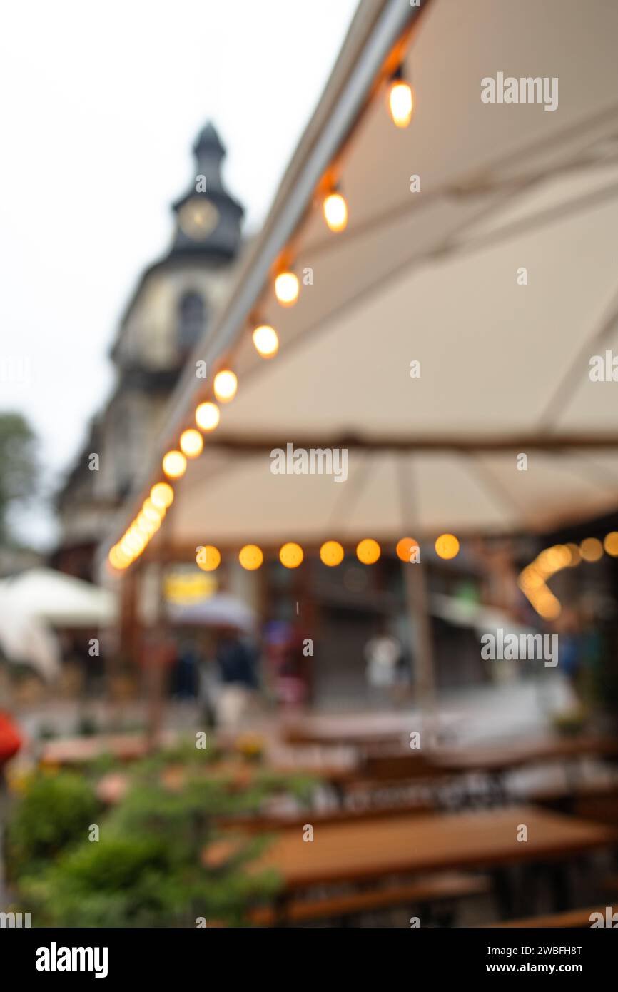 Warm festive bokeh of string lights over an outdoor bar and restaurant ...