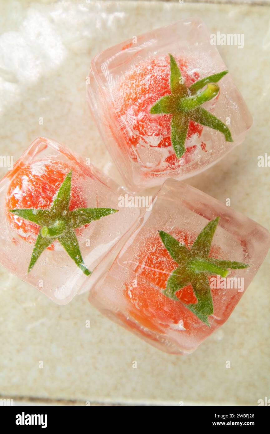 Photographic documentation of some small tomatoes inside an ice cube ...