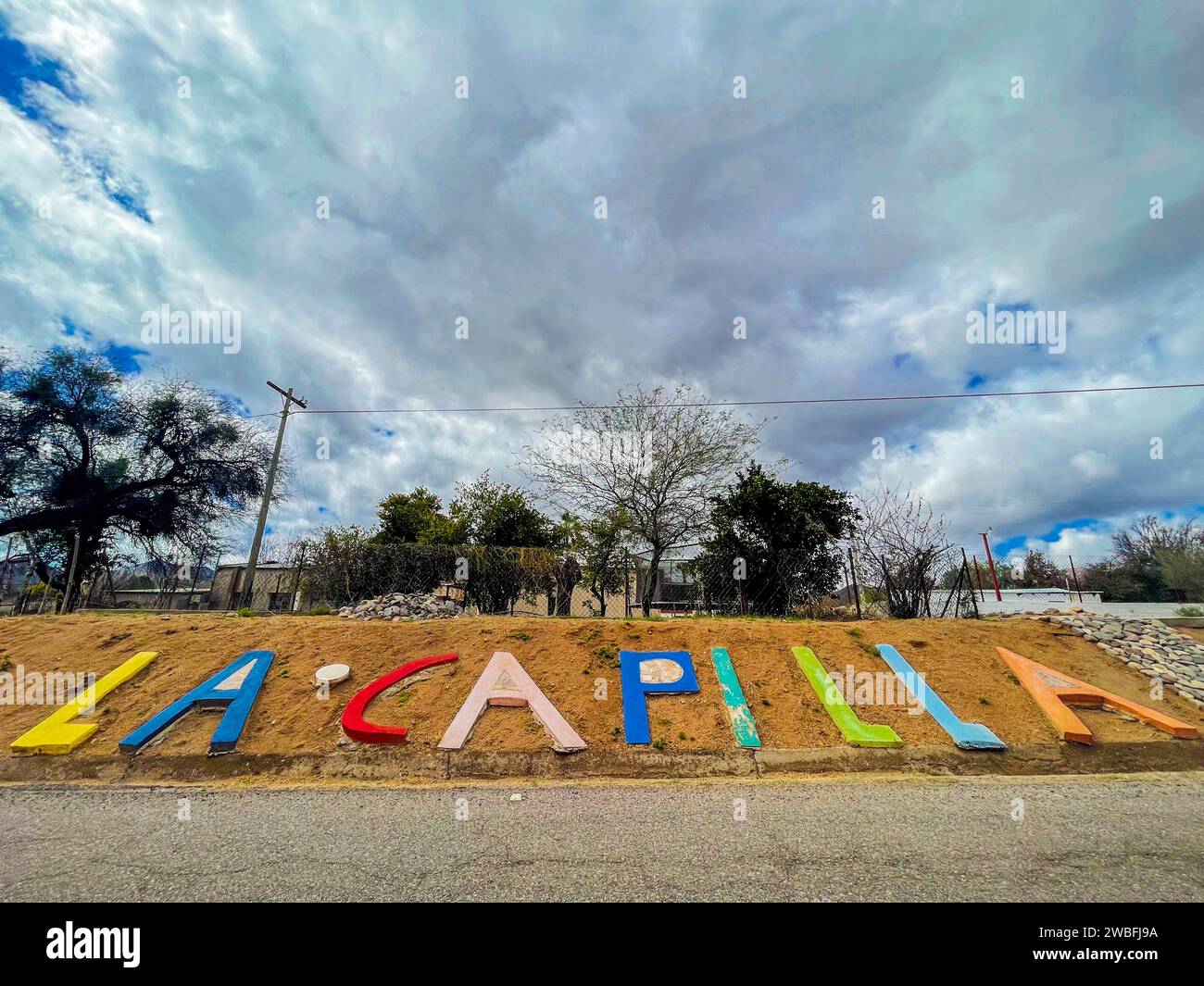Monumental colored letters of the town La Capilla on a hill on the ...