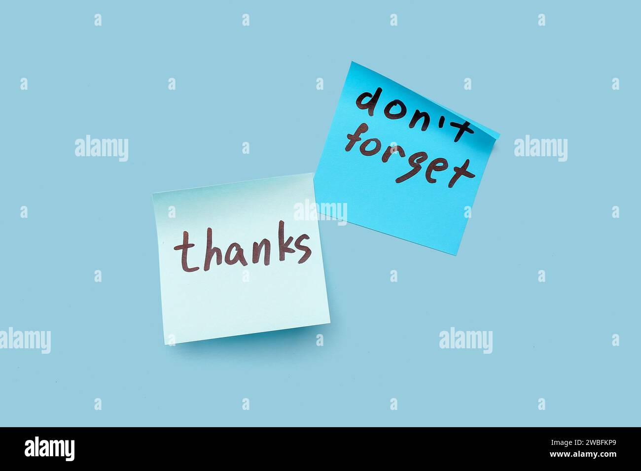Sticky notes with word THANKS and text DON'T FORGET on blue background ...