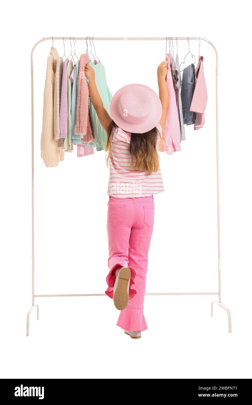 Cute little girl near rack with stylish clothes on white background ...