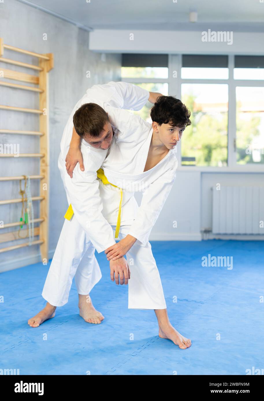 Coach teaches judo techniques to teenager during individual training ...