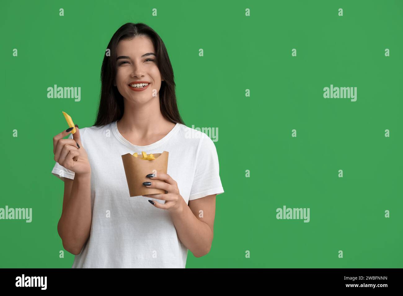 Beautiful young woman with french fries on green background Stock Photo ...
