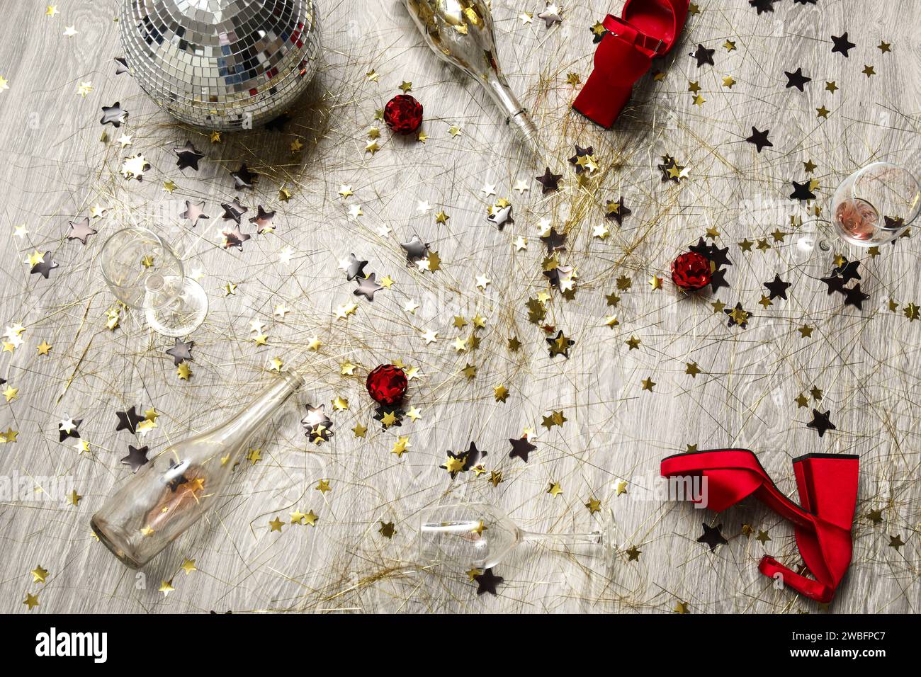 Mess with confetti on light wooden floor after party, top view Stock ...
