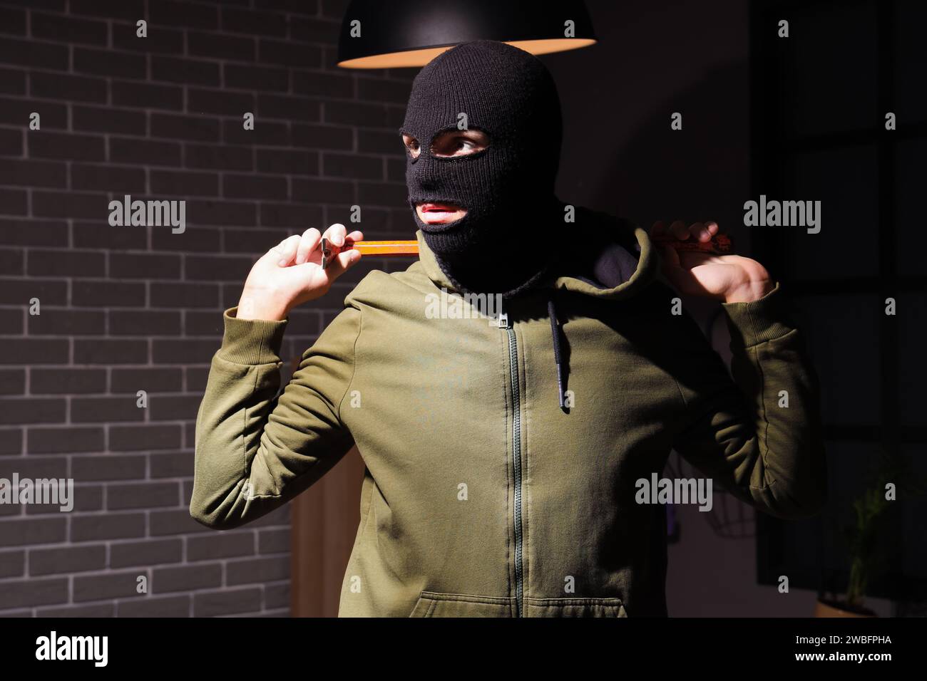 Male thief with crowbar in room at night Stock Photo - Alamy