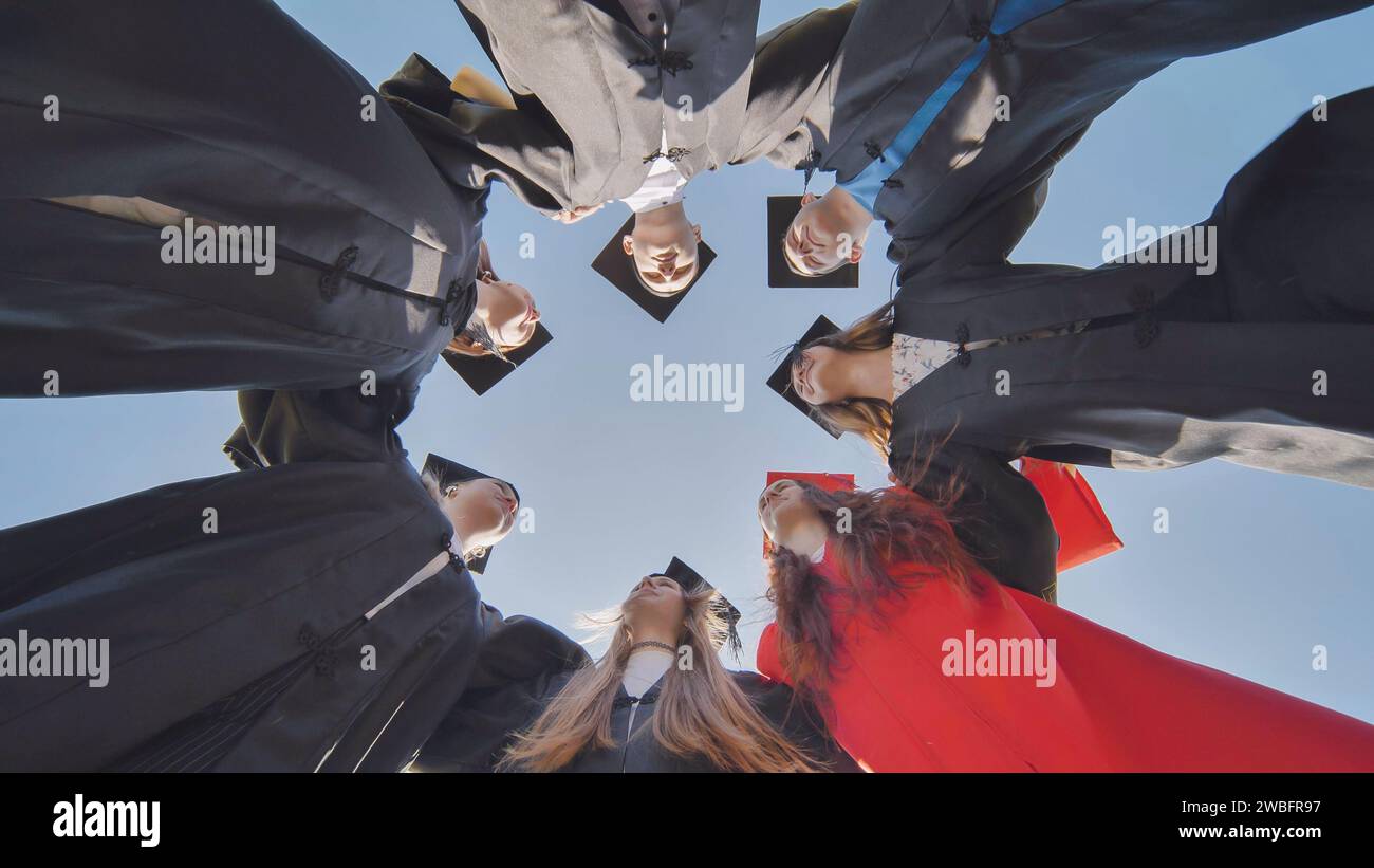 College graduates in a circle stand hugging each other Stock Photo - Alamy