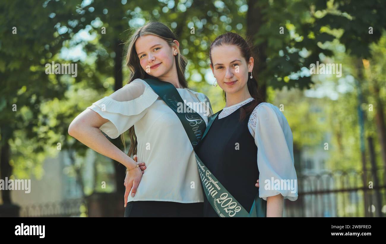 Two Russian schoolgirls graduate posing on a summer day Stock Photo - Alamy