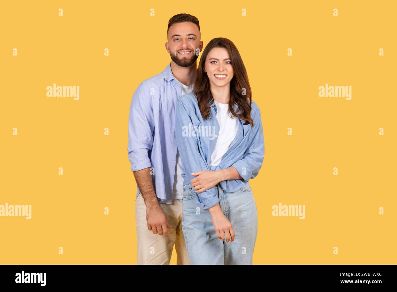 Happy european couple posing together on yellow background Stock Photo ...