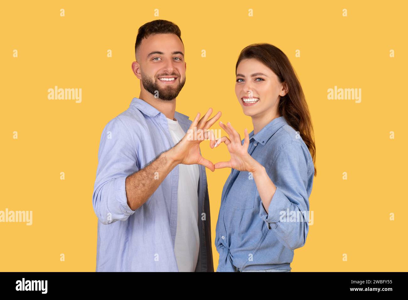 Happy couple forming heart shape with hands, affectionate pose Stock ...