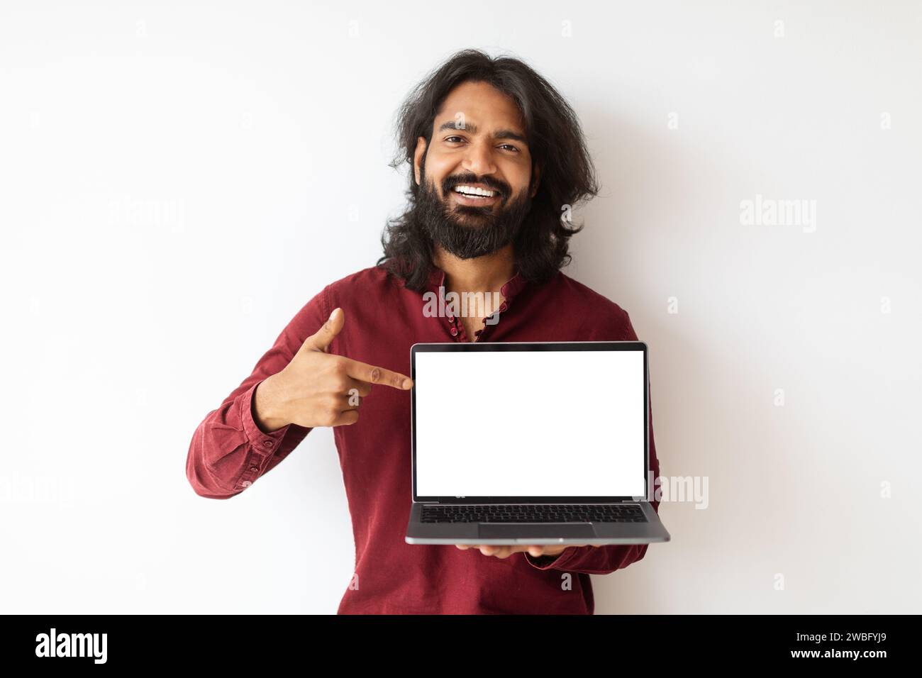 Cool young indian man showing laptop with white screen Stock Photo - Alamy