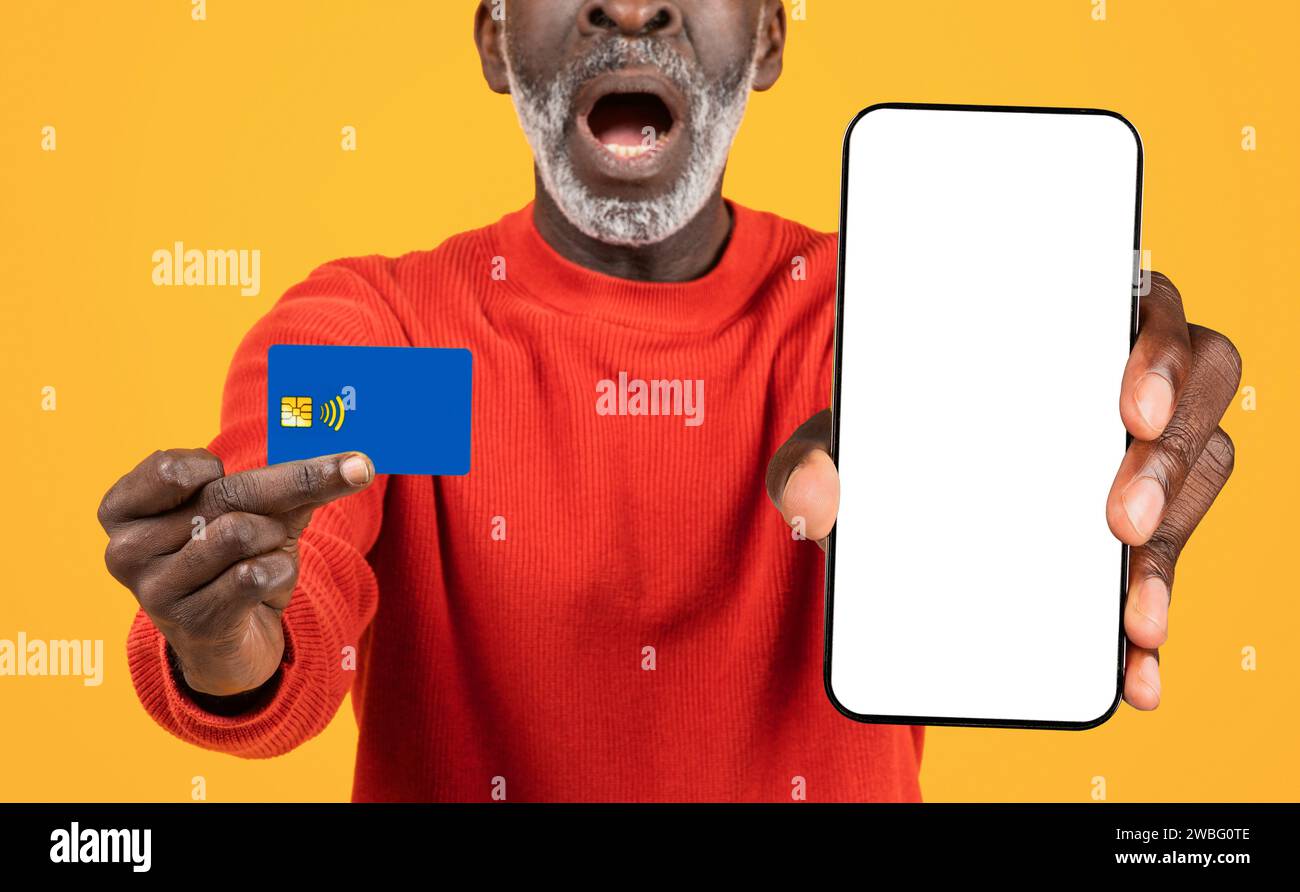 Shocked old black man show credit card and mobile smartphone with blank ...