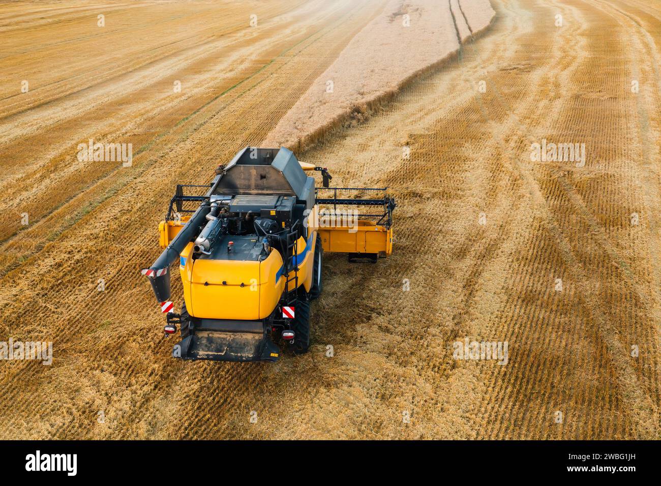 Yellow combine harvester gathers wheat with cutter bar in field aerial ... Yellow combine harvester gathers wheat with cutter bar in field aerial ...