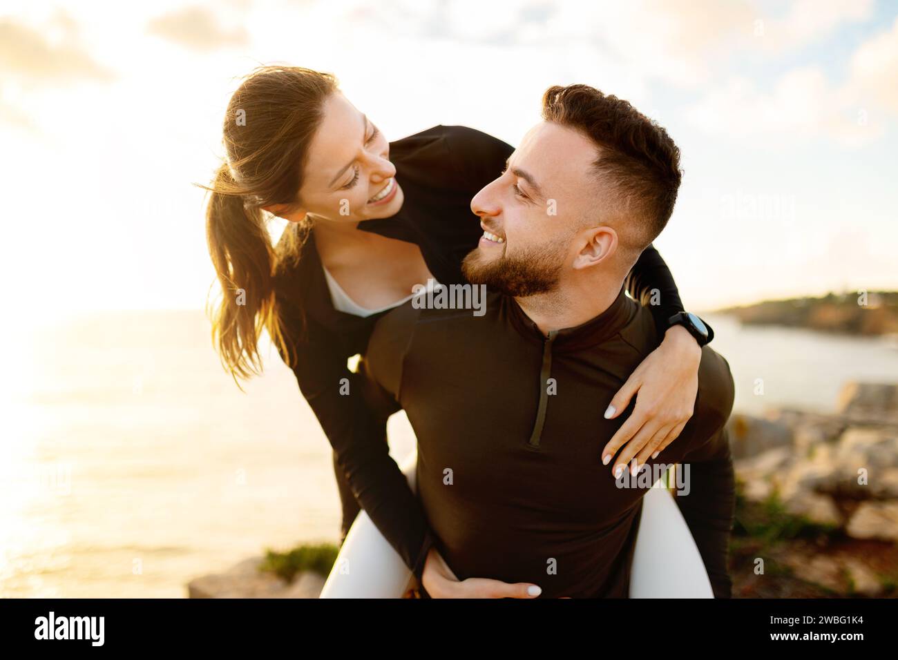 Man giving piggyback ride to lady, both in workout attire Stock Photo ...