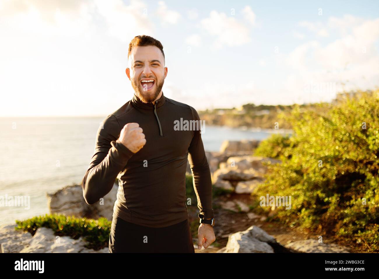 Ecstatic man celebrating with fist pump by the ocean Stock Photo - Alamy