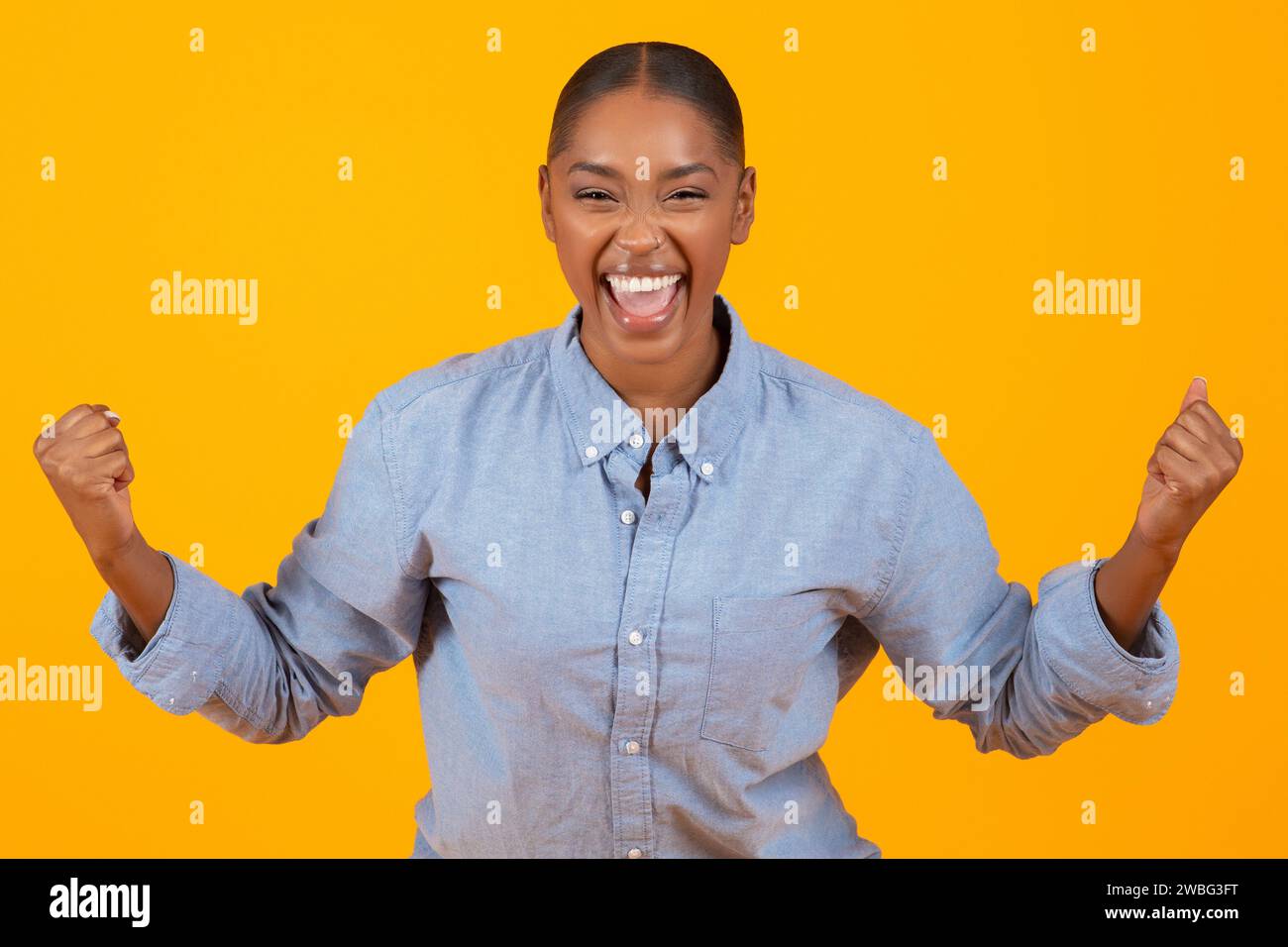 black lady screaming with joy shaking fists over yellow background ...