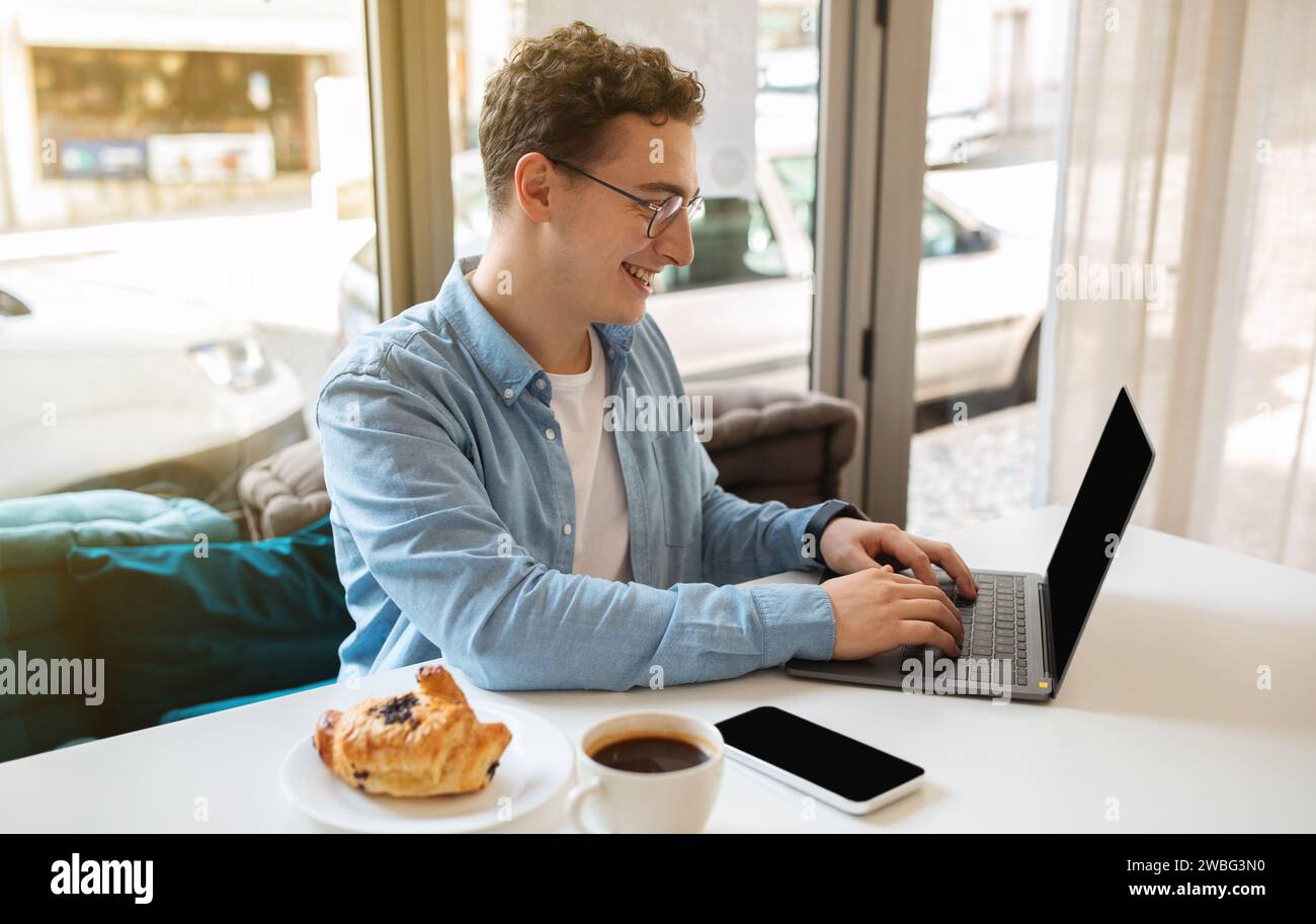Positive busy millennial caucasian guy in glasses, typing on computer ...