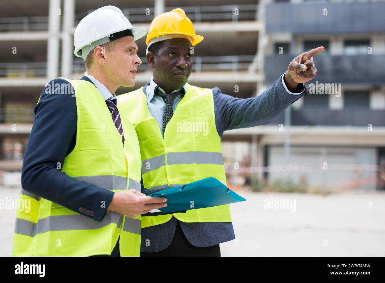 Two architect, civil engineer or building contractor colleagues on ...