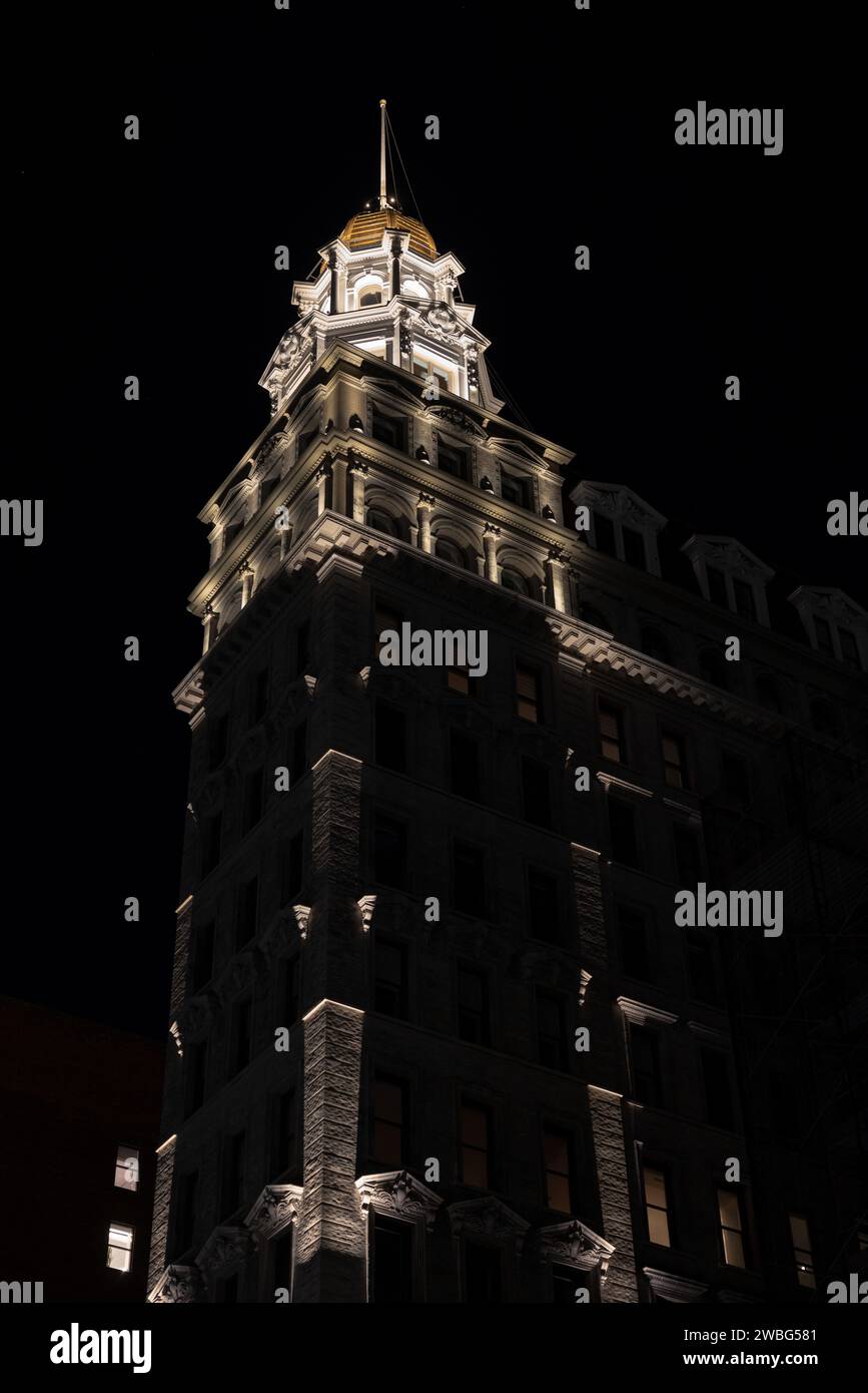 A majestic tower illuminated by golden lighting at night, featuring two ...