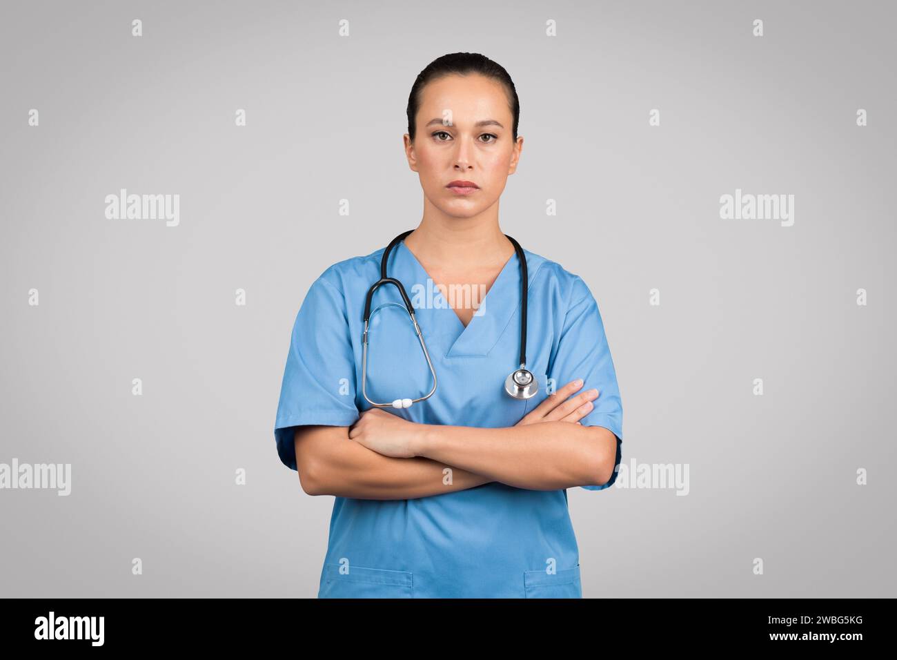 Stern nurse with arms crossed in scrubs Stock Photo - Alamy