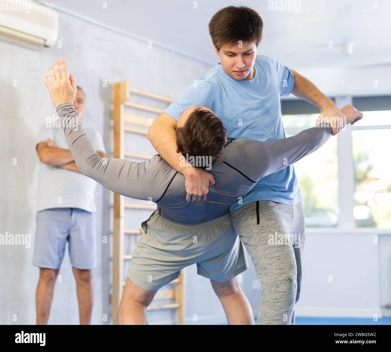 Adult and young men training self-defense techniques Stock Photo - Alamy