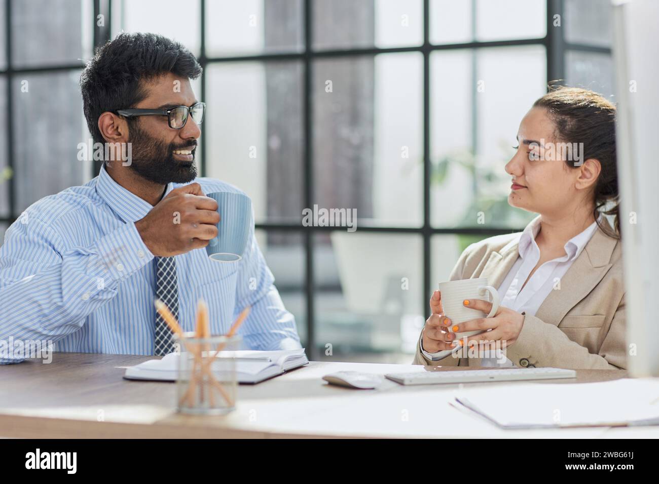 colleagues talking during lunch break while sitting at workplace Stock ...