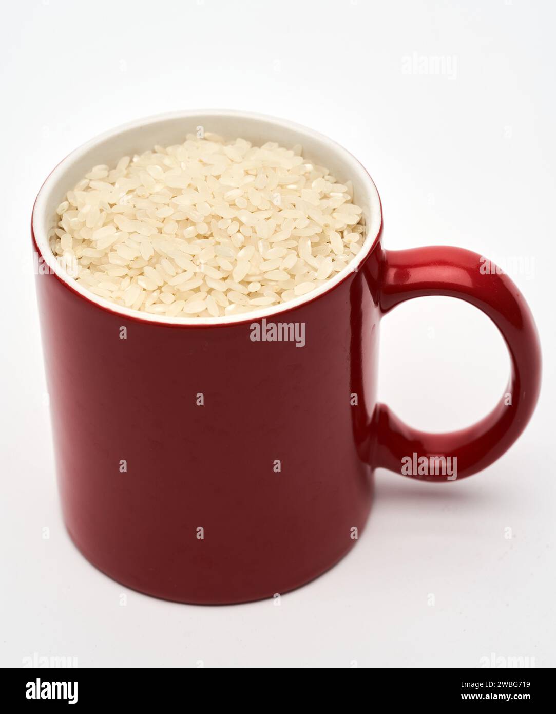 Raw Chinese rice in a red cup, isolated on white background Stock Photo ...
